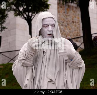 Street artist playing disguised as a white statue Stock Photo - Alamy