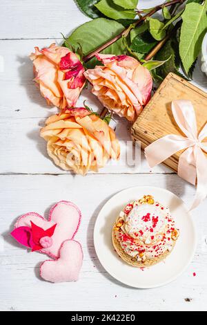 The concept of romantic gift. French Shu cake, hibiscus tea, bouquet of ...