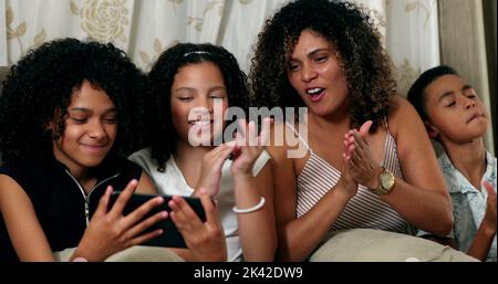 Brazilian mother and children talking to family member using tablet ...