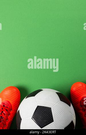 Composition of football and red shoes on blue background with copy ...