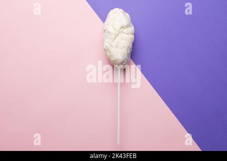 Horizontal image of homemade white candy floss on stick, on pink and ...