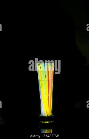 Image of vibrant stack of neon glow sticks scattered over black ...