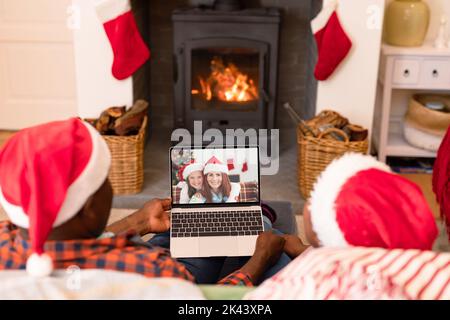 Mother and daughter making christmas laptop video call with smiling ...