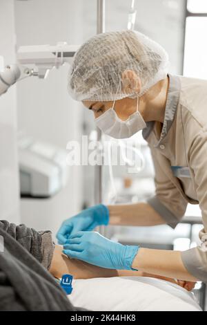 Woman with nurse during blood washing procedure at medical centre Stock ...