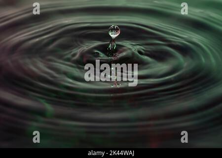 Green and red water dropping, water ripples in a pond. waves of ...