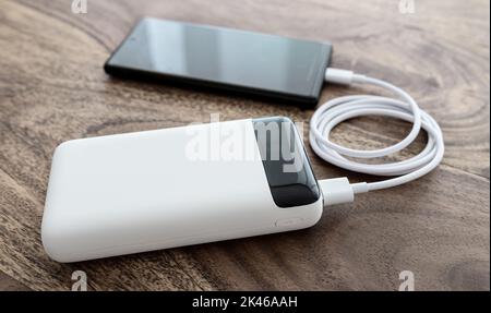 charging smartphone with power bank, high angle view Stock Photo - Alamy