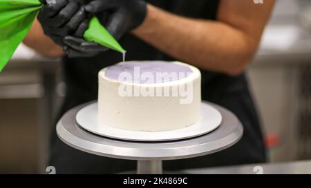 chef using using bag decorating a frosted icing cake Stock Photo - Alamy