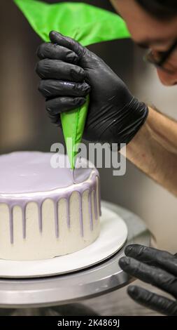 chef using using bag decorating a frosted icing cake Stock Photo - Alamy