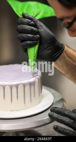 chef using using bag decorating a frosted icing cake Stock Photo - Alamy
