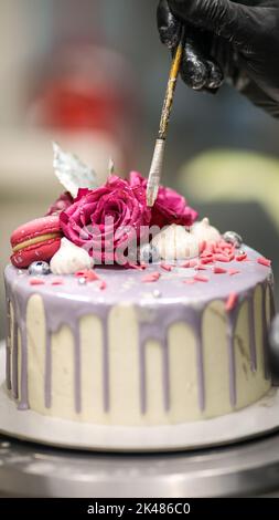 chef usign macaron , flowers and text sign for a celebration cake Stock ...