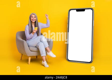 Photo of funny lucky woman wear plaid shirt sitting beanbag winning e ...