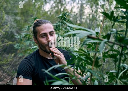 Smoking medicinal marijuana. Smiling man with a bong for smoking ...