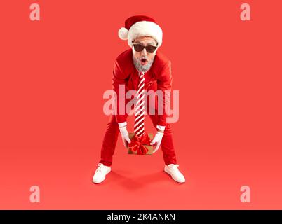 shocked santa claus holding christmas sack over shoulder isolated on ...