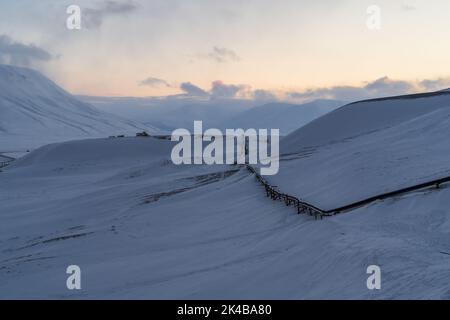 Raised pipelines through snowy Svalbard landscape, Longyearbyen Stock ...