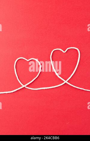 Image of hearts made of white string on red surface Stock Photo - Alamy