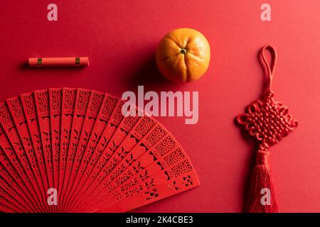Composition of traditional chinese fan and decorations on red ...
