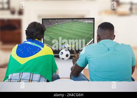 Diverse male friends supporting and watching tv with football match on ...
