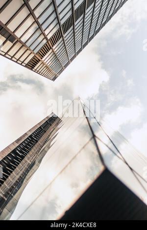 A vertical low angle shot of glass buildings and skyscrapers against ...