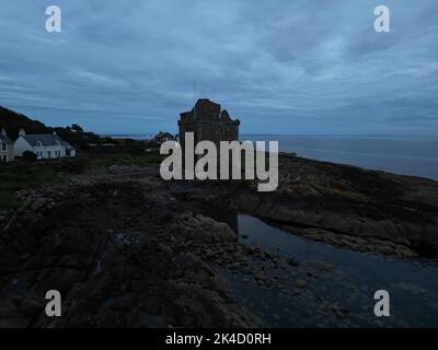 A beautiful view of the old Portencross castle with a flag on the top ...