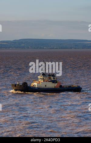 Tug heading to escort vessel into port Stock Photo - Alamy