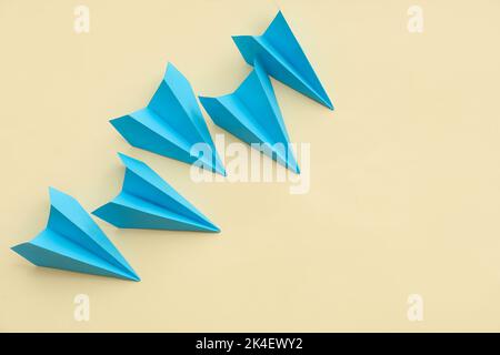 Blue paper planes on beige background Stock Photo - Alamy