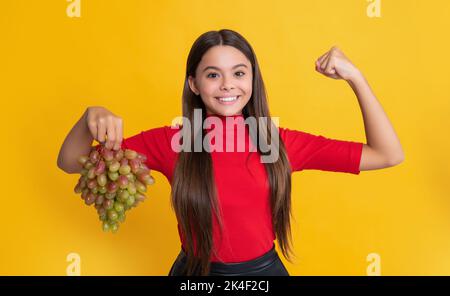 successful child hold fresh grapes fruit on yellow background Stock ...