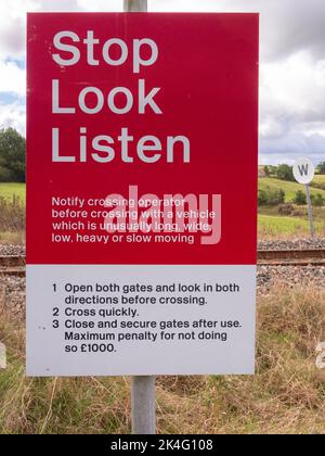 Railroad crossing stop look and listen sign white with black letters ...