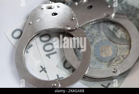 Police handcuffs and banknotes in Polish currency. The concept of ...