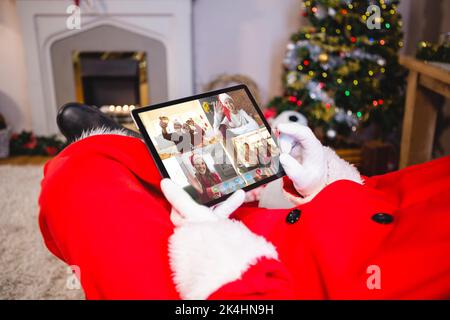Santa claus making tablet christmas video call with smiling caucasian ...