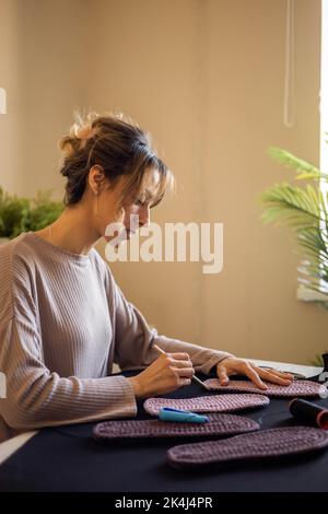 Female knitted clothes and shoes designer sketching drawing sample ...