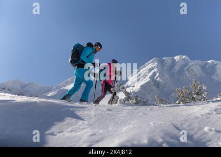 Low angle view of ski touring couple hiking up in mountains Stock Photo ...