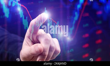 The trader points his finger at the stock chart on the monitor Stock ...