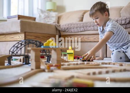 Preschool baby boy playing wooden Montessori materials rainbow arch ...
