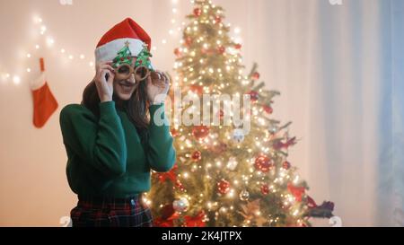 Girl dances next to christmas tree Stock Photo - Alamy
