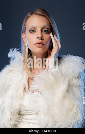 pierced young woman with winter makeup and white eyebrows posing with ...