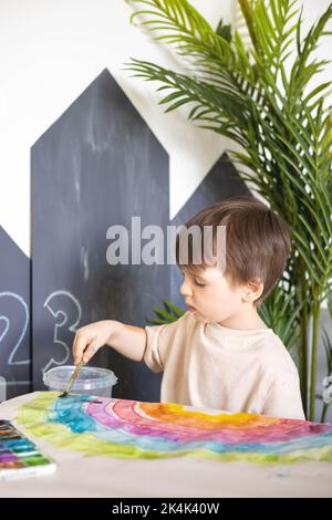 Confident cute male kid art drawing multicolored rainbow arch use ...