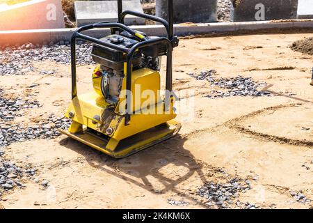 Gasoline Vibrating rammer with a vibrating plate on a construction site ...