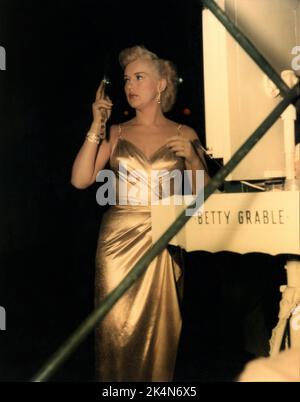 BETTY GRABLE on set candid smoking cigarette during break in filming of ...