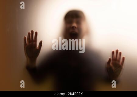 Shadow of woman screaming behind the glass, domestic violence concept ...
