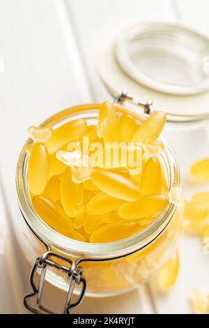 A jar of omega 3 fish oil capsules on a blue background with space for ...