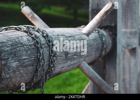 Old wooden winch of well with chain. lifting mechanism of water from ...