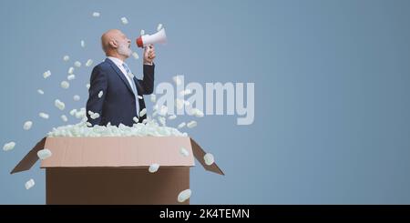 Businessman shouting with a megaphone in a delivery box, business and ...