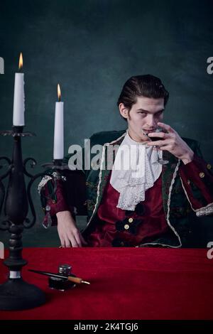 Portrait of terrifying man in image of vampire, Dracula drinking blood ...