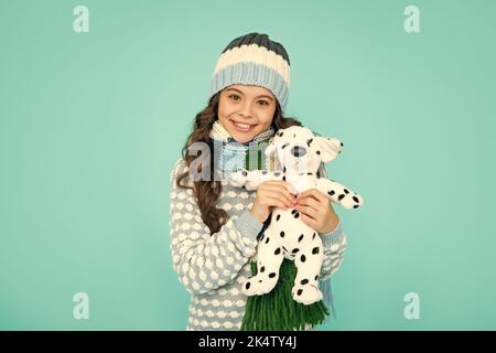 cheerful child in knitwear hold toy. teen girl on blue background ...