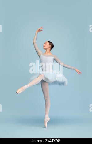 Theatrical performance. Beautiful, tender, graceful ballerina dancing against dark blue ...