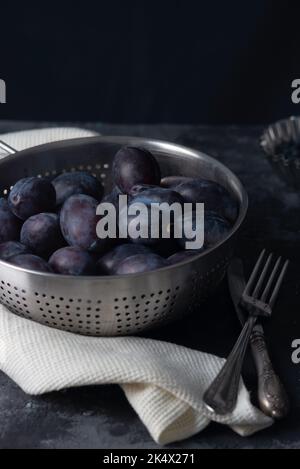 dramatic autumn still life with plums on a dark background. Rustic ...