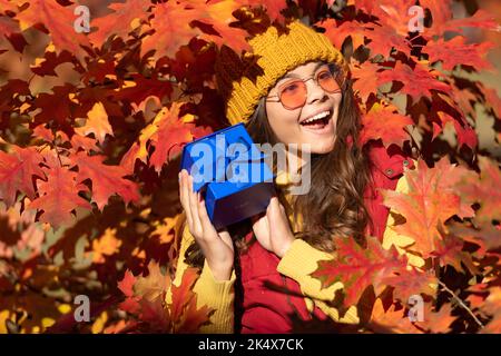 Amazed teenager. Child with gift present box on isolated background ...
