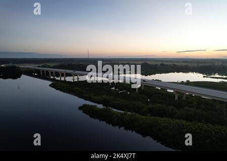 The view of Fort Hamer Bridge and trees under the blue sky reflected in ...