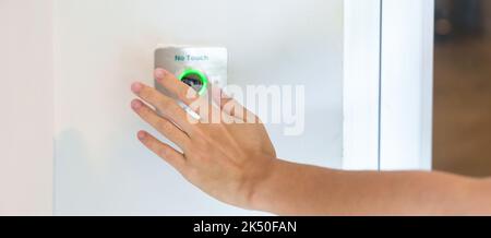 Hand open the door by No touch sensor switch on the wall at office or ...