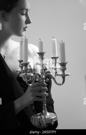 A vertical greyscale shot of an attractive female posing with a ...